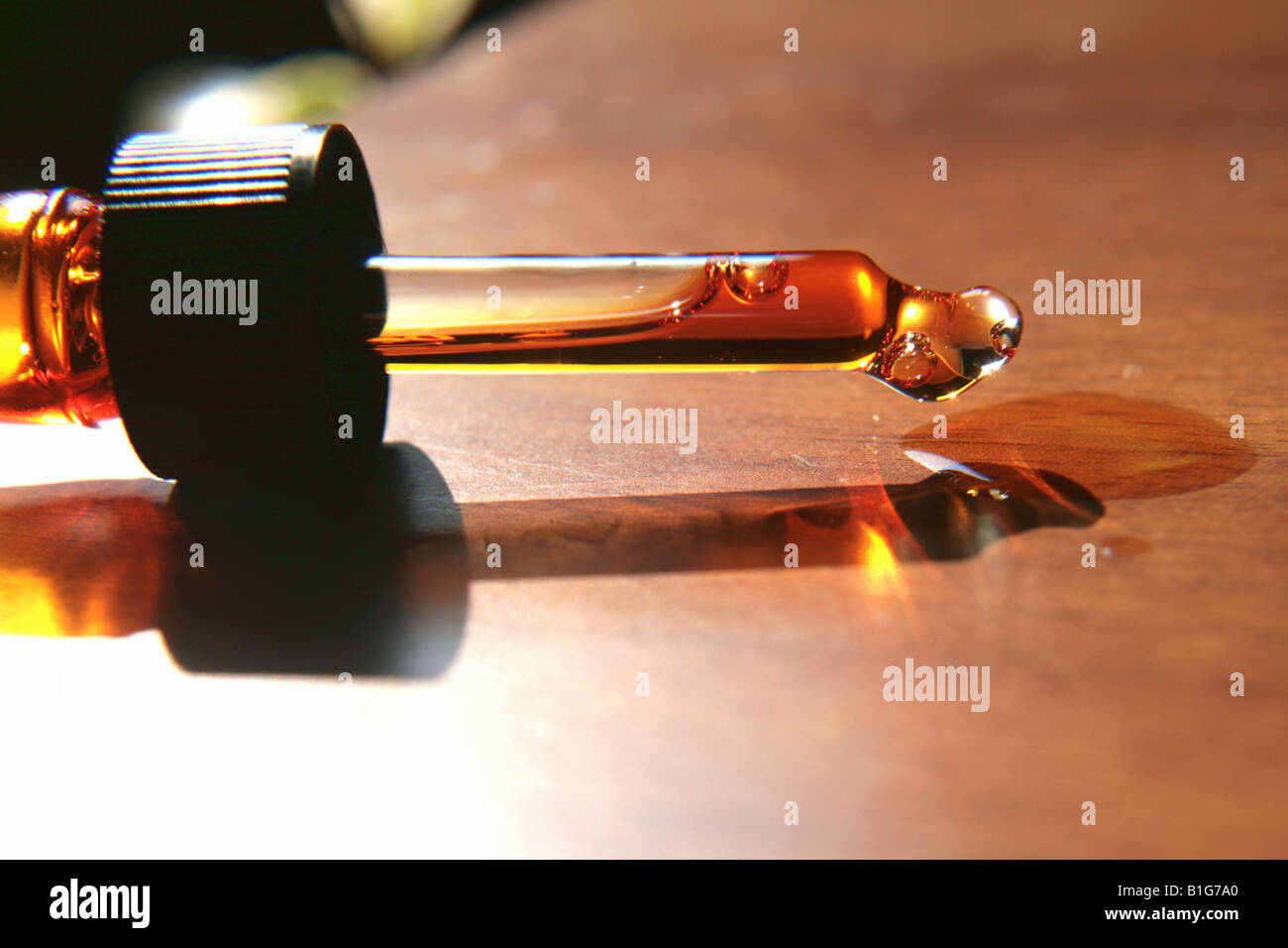 Closeup of a dropper dispensing drop Stock Photo - Alamy