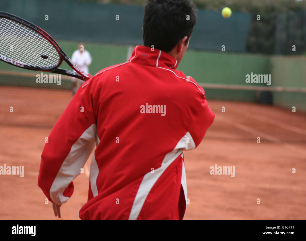 Rear view of a man playing tennis Stock Photo - Alamy