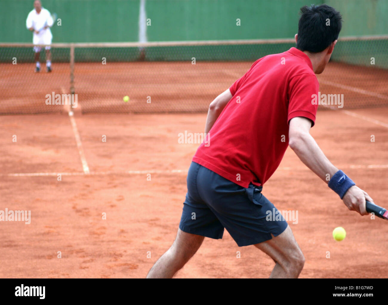 Rear view of a man playing tennis Stock Photo - Alamy