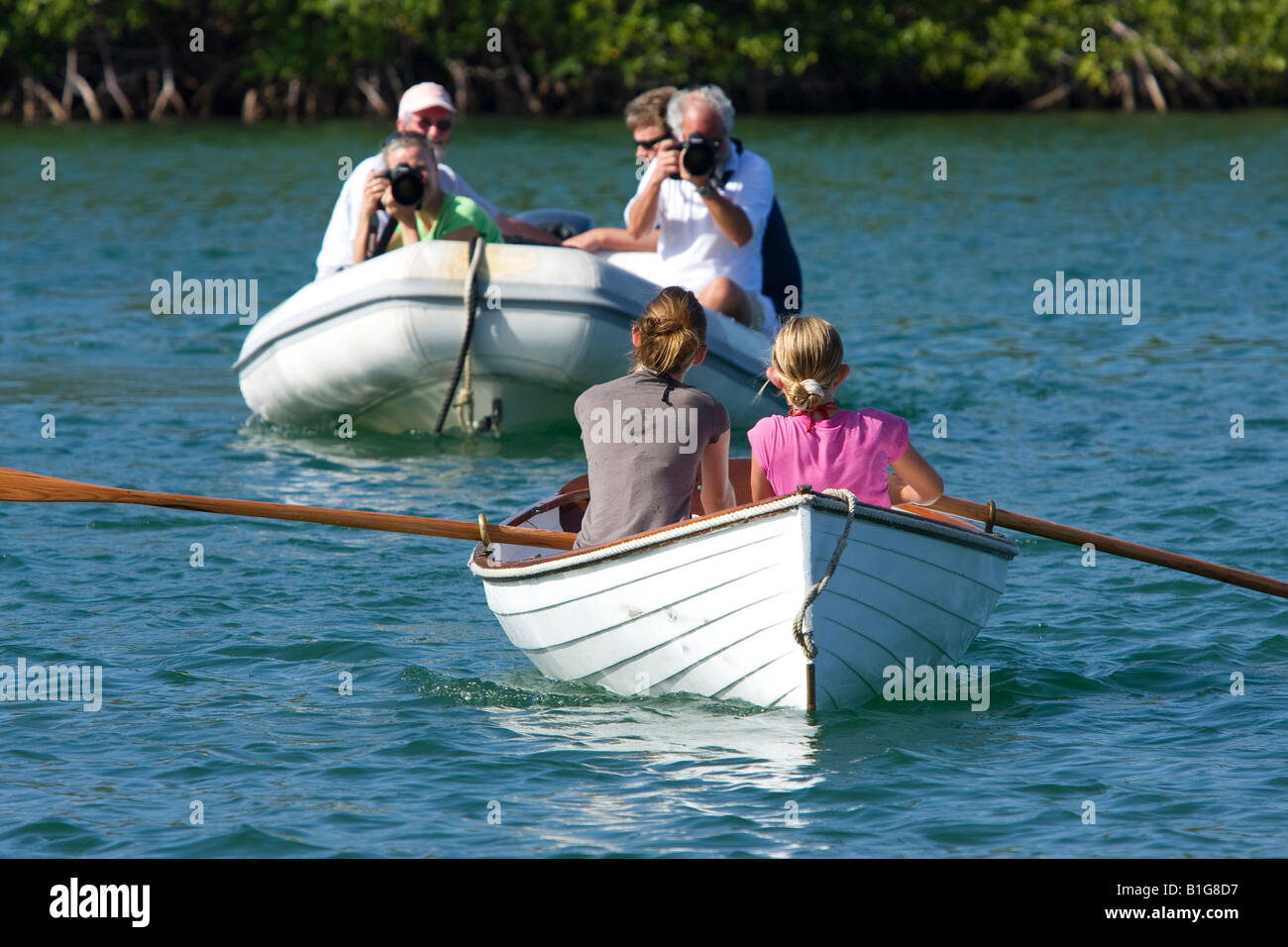 Photographers take photographs of competitors during a rowing dinghy ...
