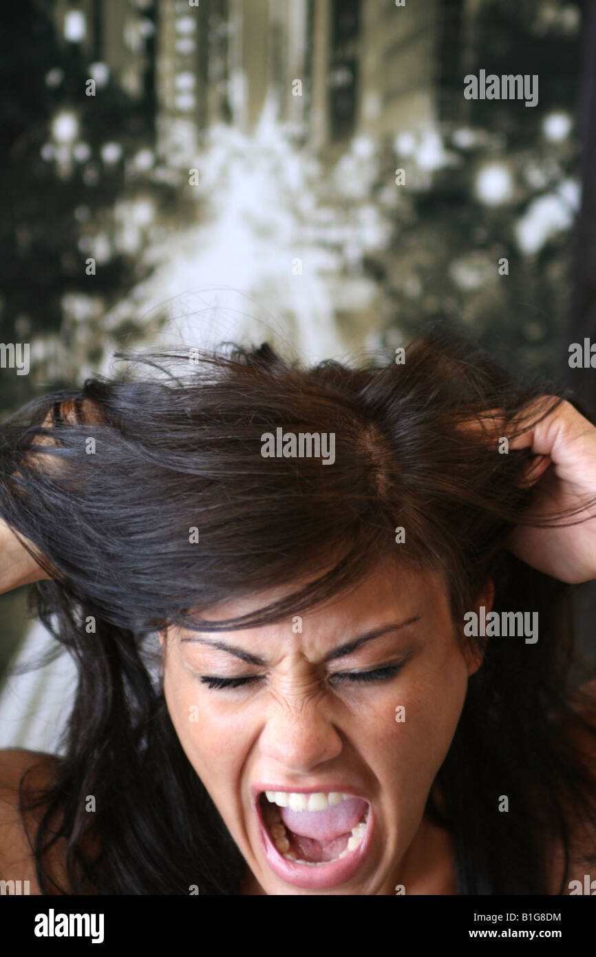 A woman screaming and pulling her hair in frustration Stock Photo - Alamy