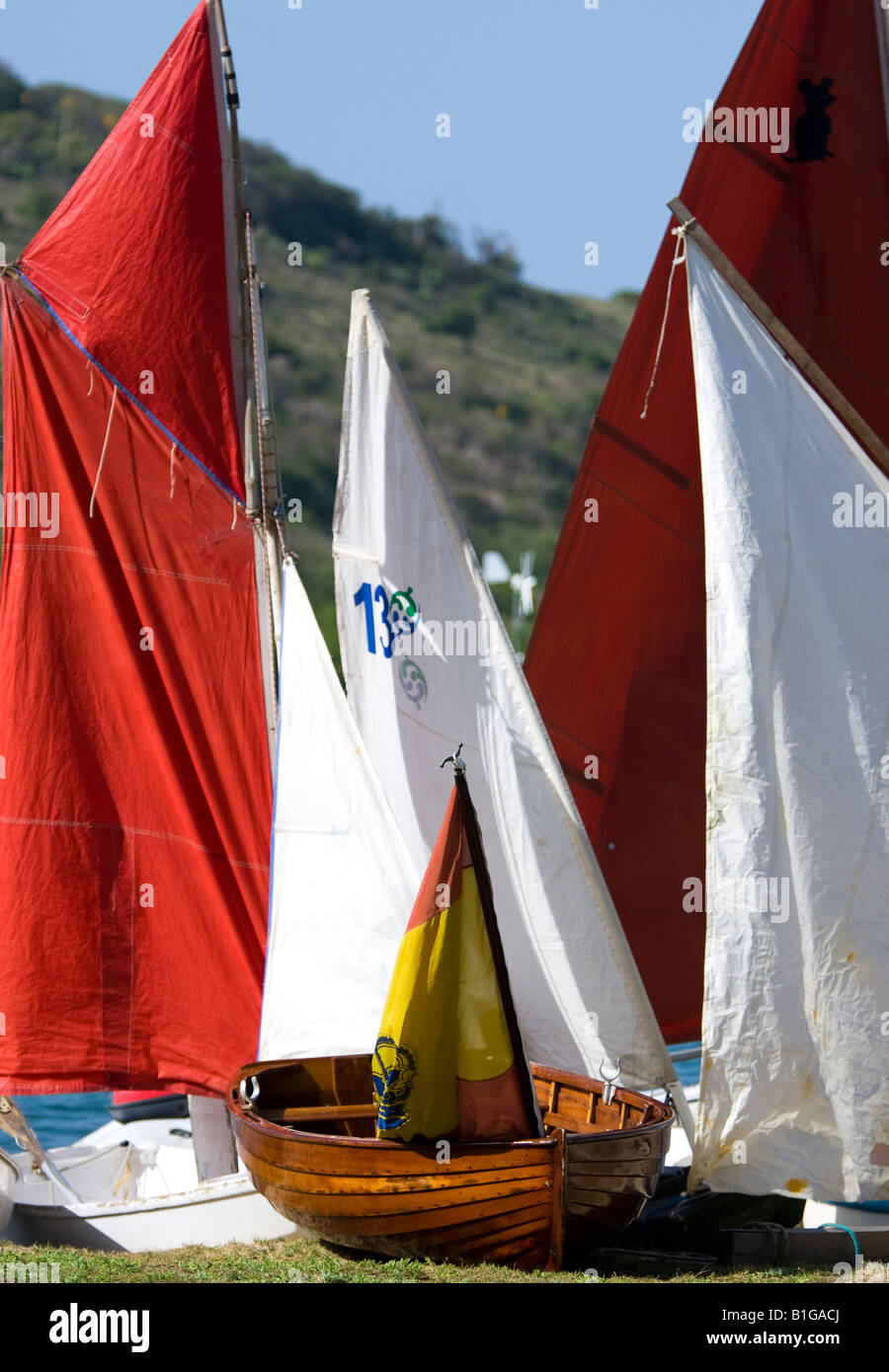 A rigged rowing dinghy sits on the grass in English Harbor surrounded ...
