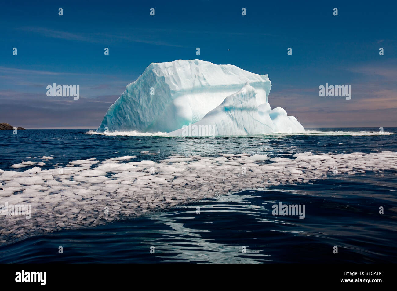 Shattered ice fragments from an iceberg float on the ocean's surface ...