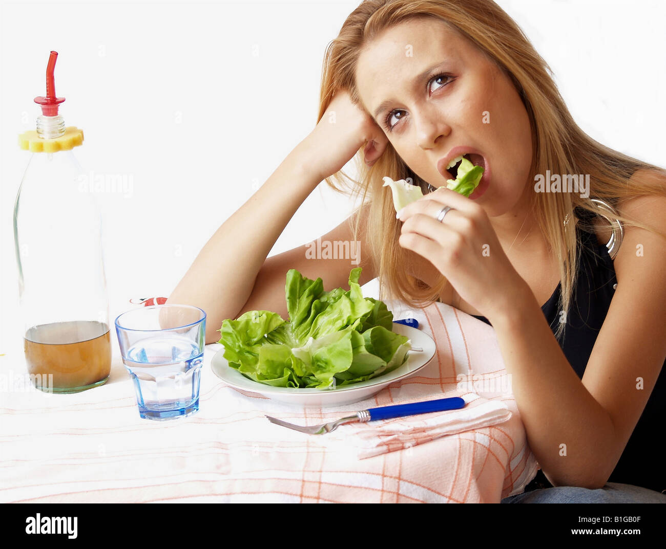 Front view of a young woman eating lettuss Stock Photo - Alamy