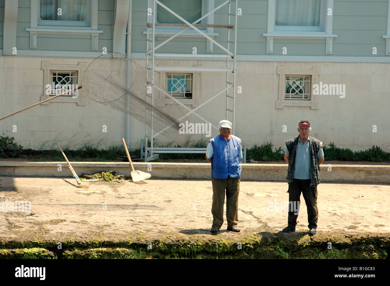 Men fishing with small net and pole Stock Photo - Alamy