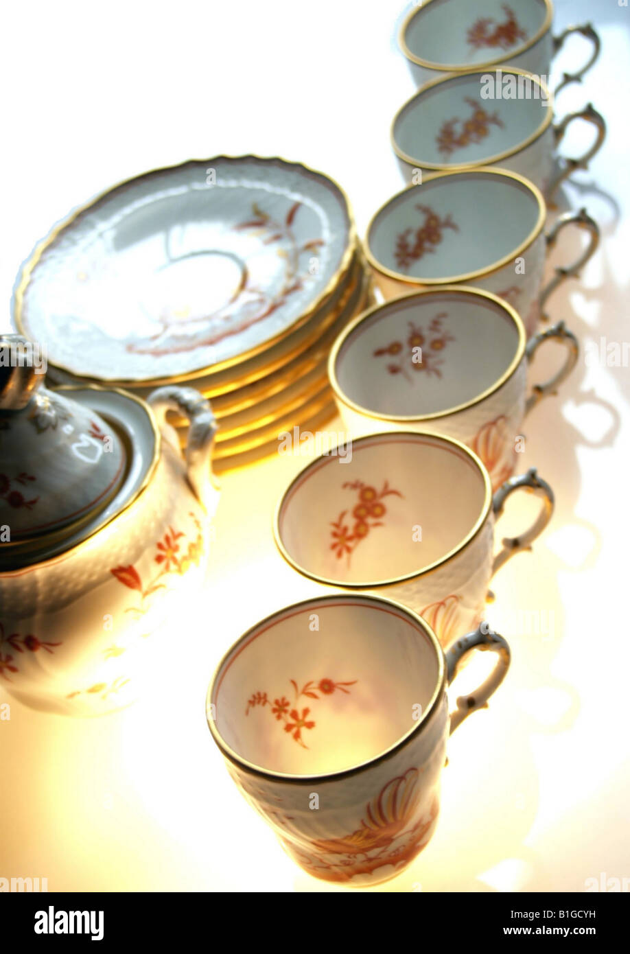 Overhead view of teacups arranged in a row with saucers and kettle ...
