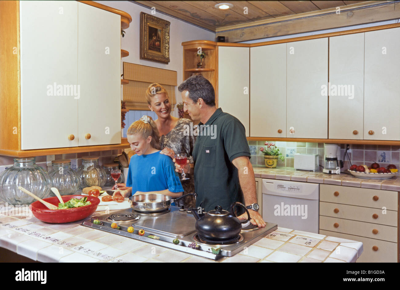 Family cooking, preparing dinner together in kitchen, Miami Stock Photo ...