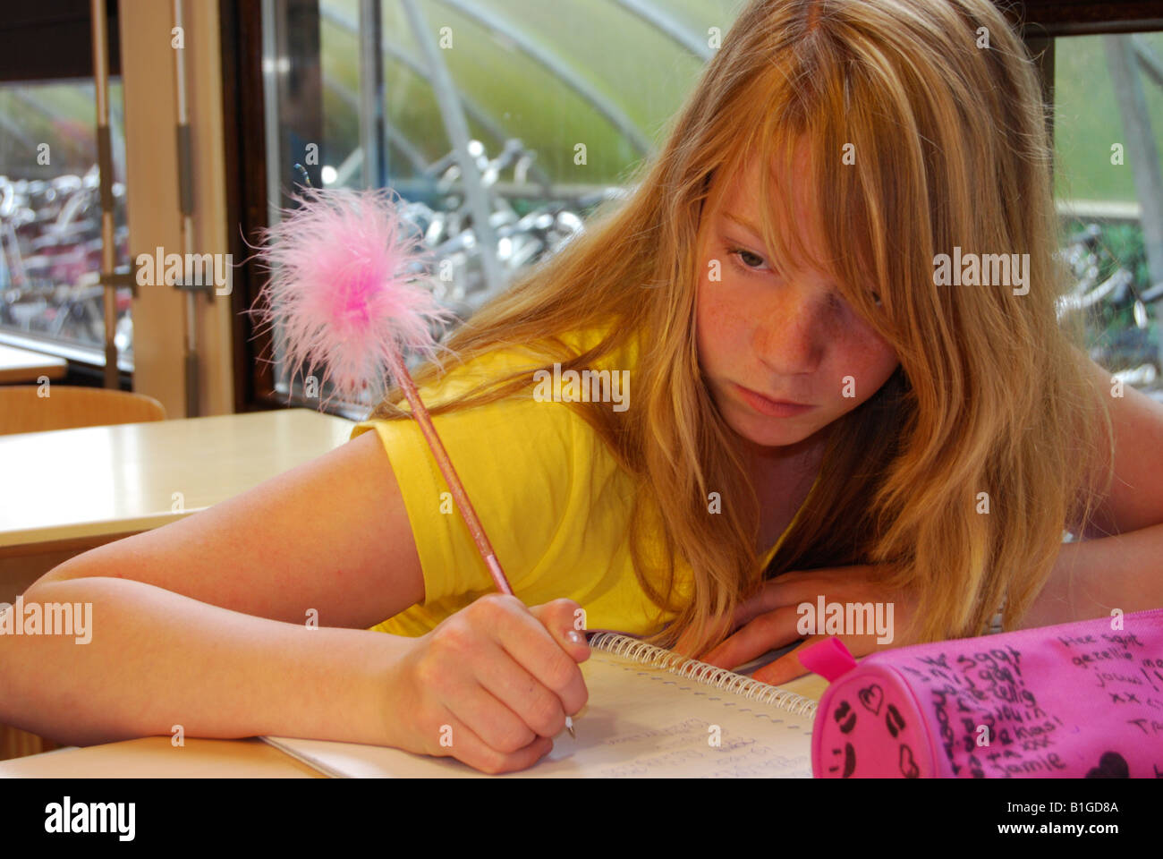 student in class writing in her notebook with fluffy pen Stock Photo ...