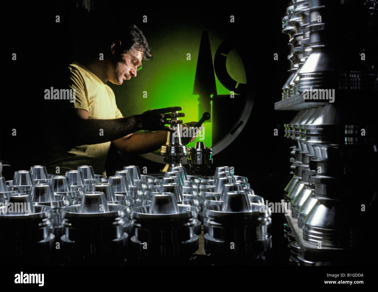 American worker uses parts comparator to inspect precision machine ...