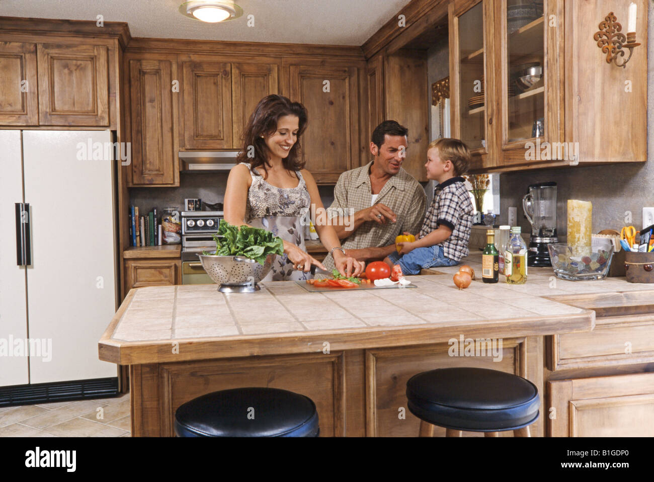 Family cooking, preparing dinner together in kitchen, Miami Stock Photo ...