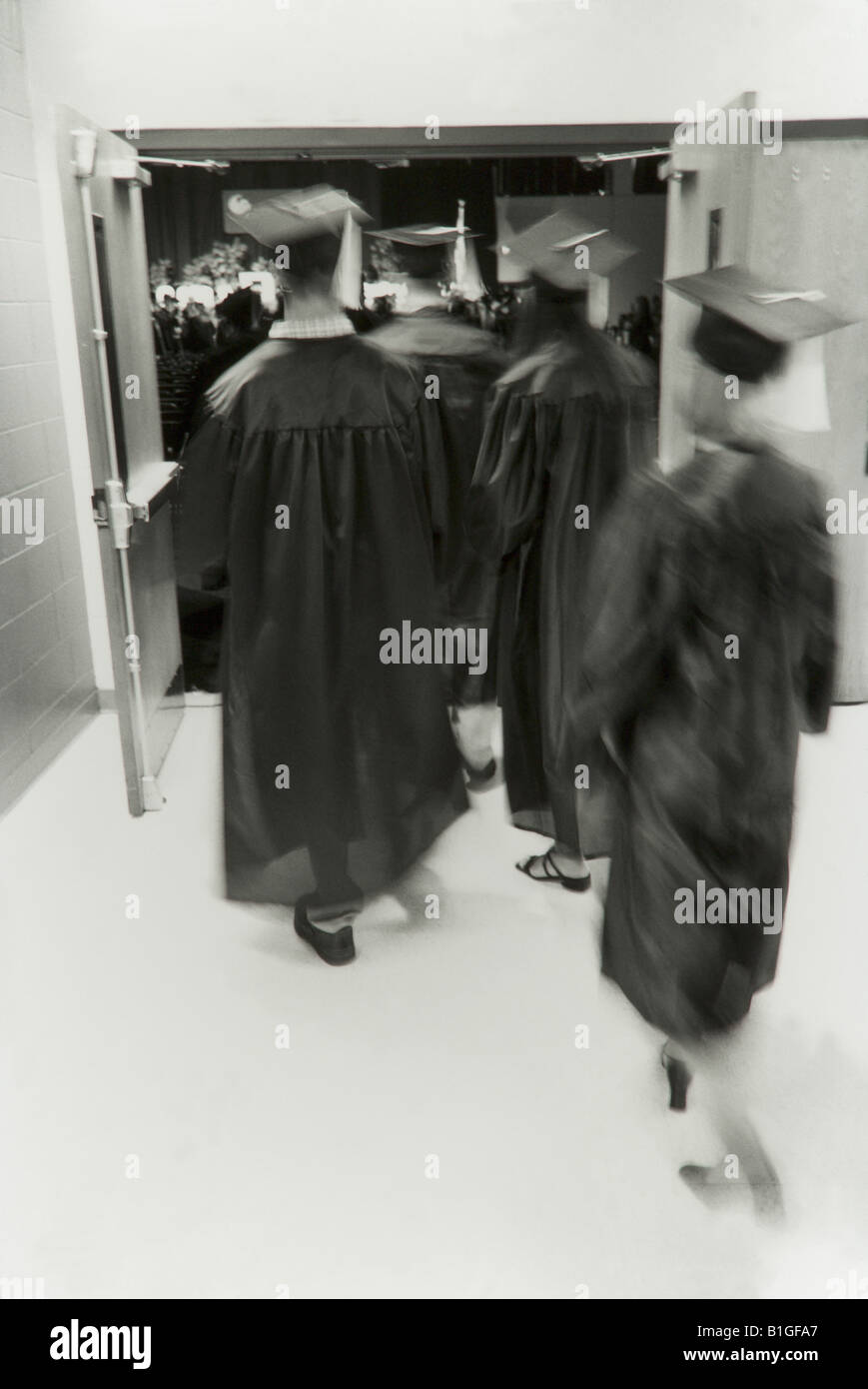 College graduates at commencement ceremony, wearing graduation robes ...