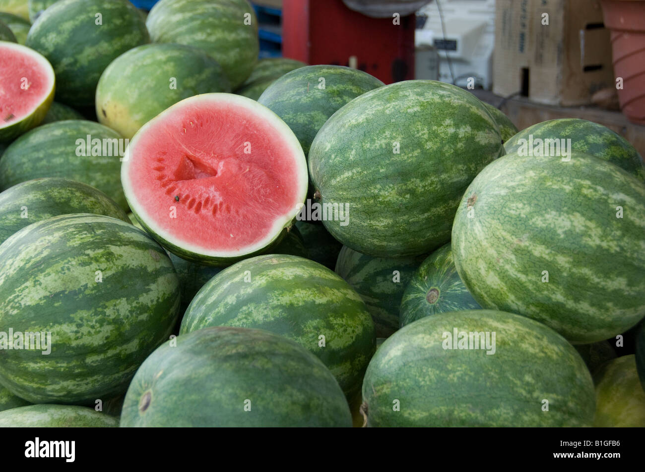 Stack of watermelons with one cut at a Farmer's Market symbolizing to ...