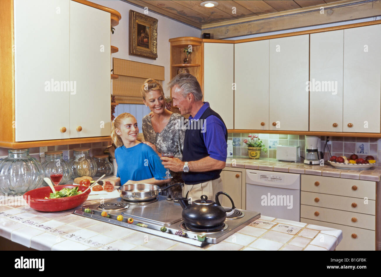 Family cooking, preparing dinner together in kitchen, Miami Stock Photo ...