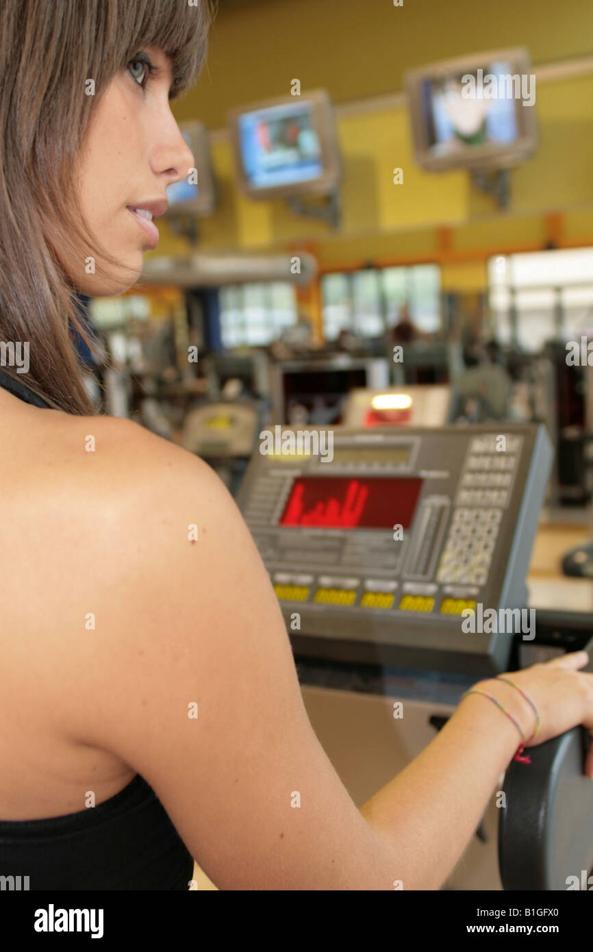 A young woman working out on exercise machine Stock Photo - Alamy
