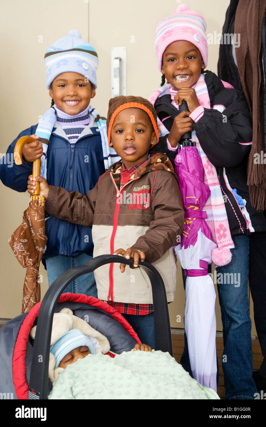 Three African American children and a toddler wait in line for a ... Three African American children and a toddler wait in line for a ...