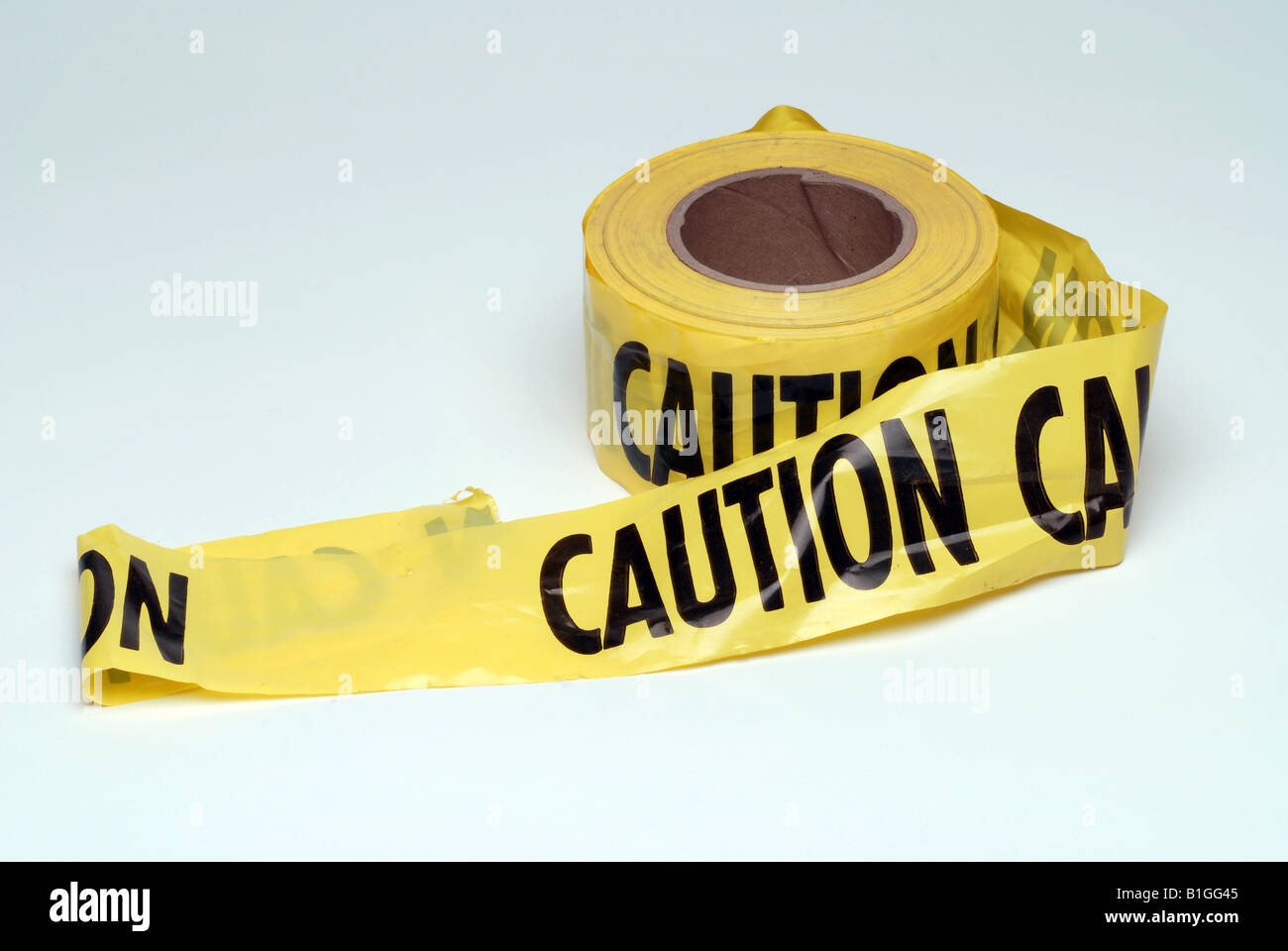 Yellow roll of caution tape on white background Stock Photo - Alamy