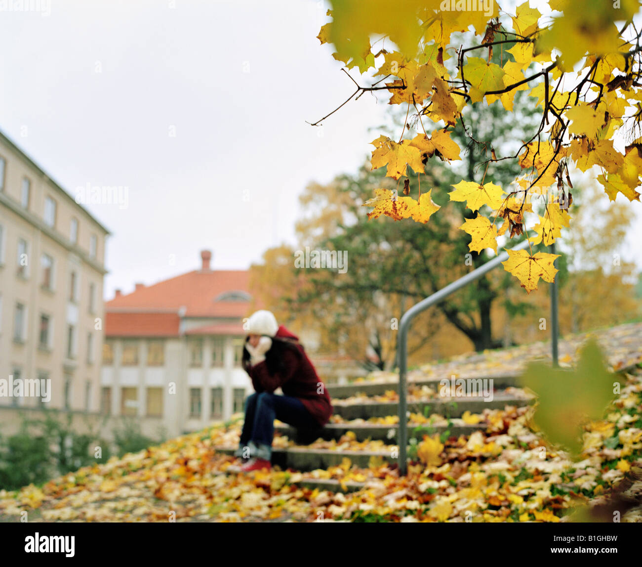 Side profile of a teenage girl sitting on steps in a park Stock Photo ...