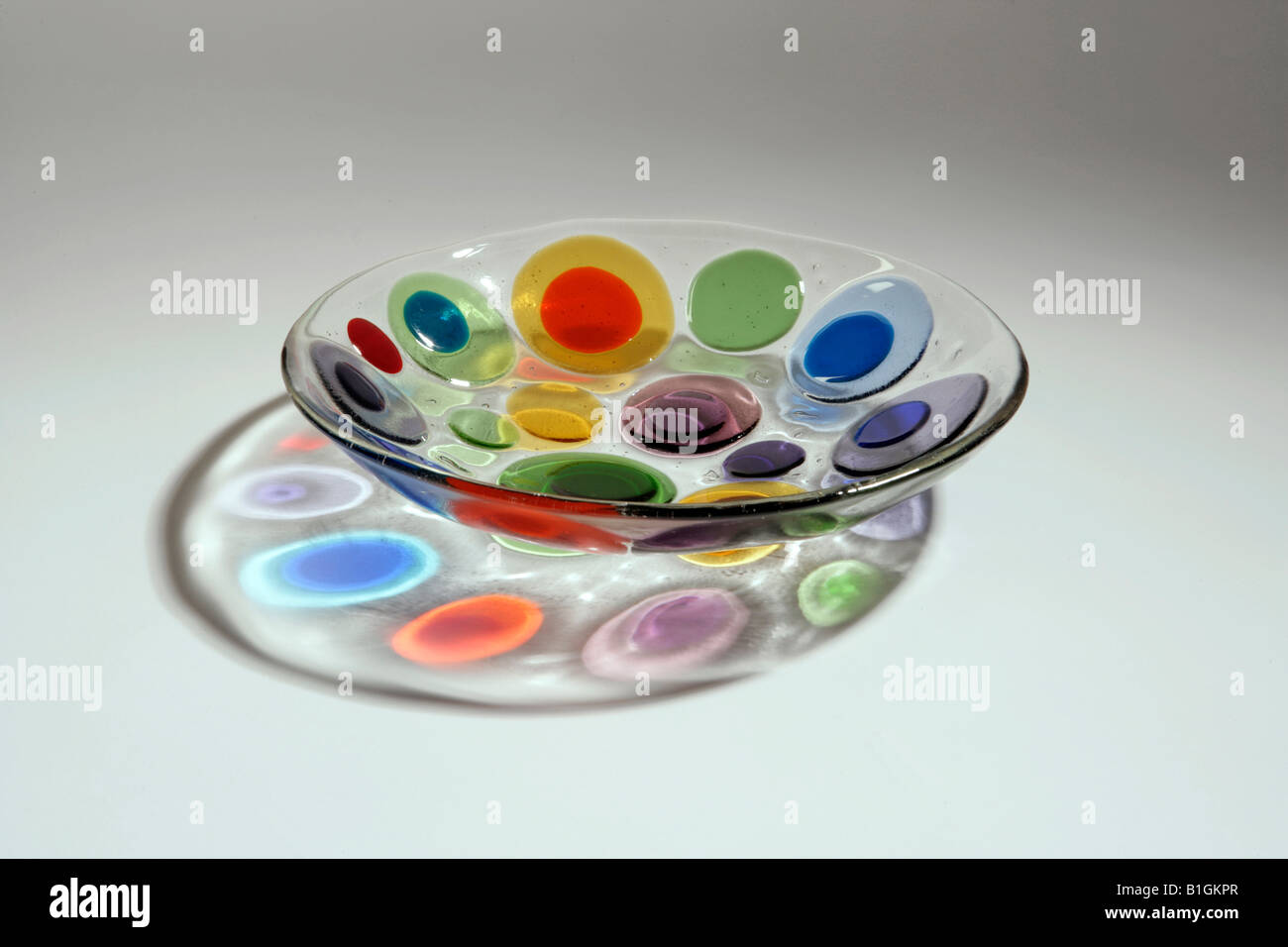 coloured glass plate with circles of colour on it. Light shining from ...