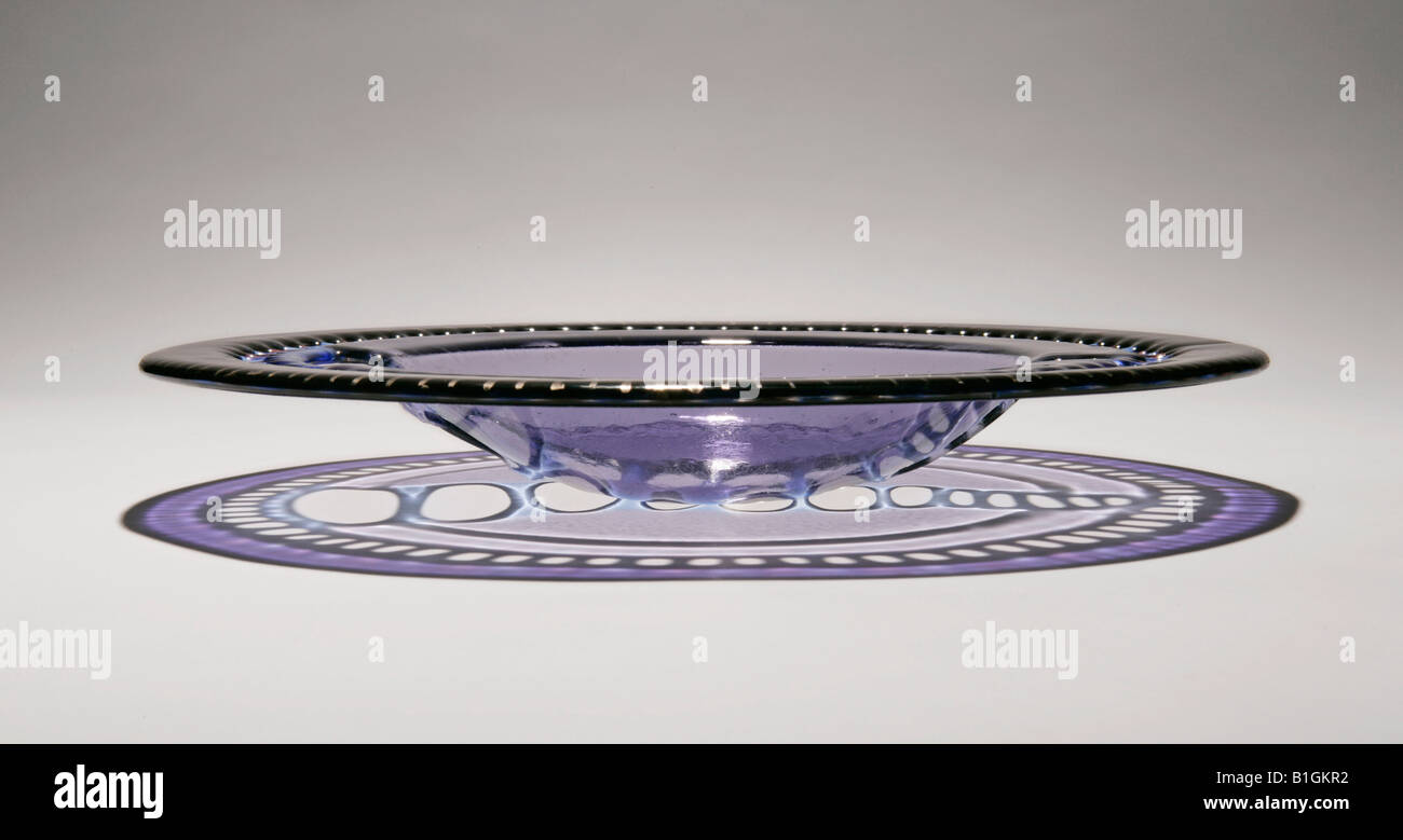 blue glass plate with holes in and light shining through it from above ...