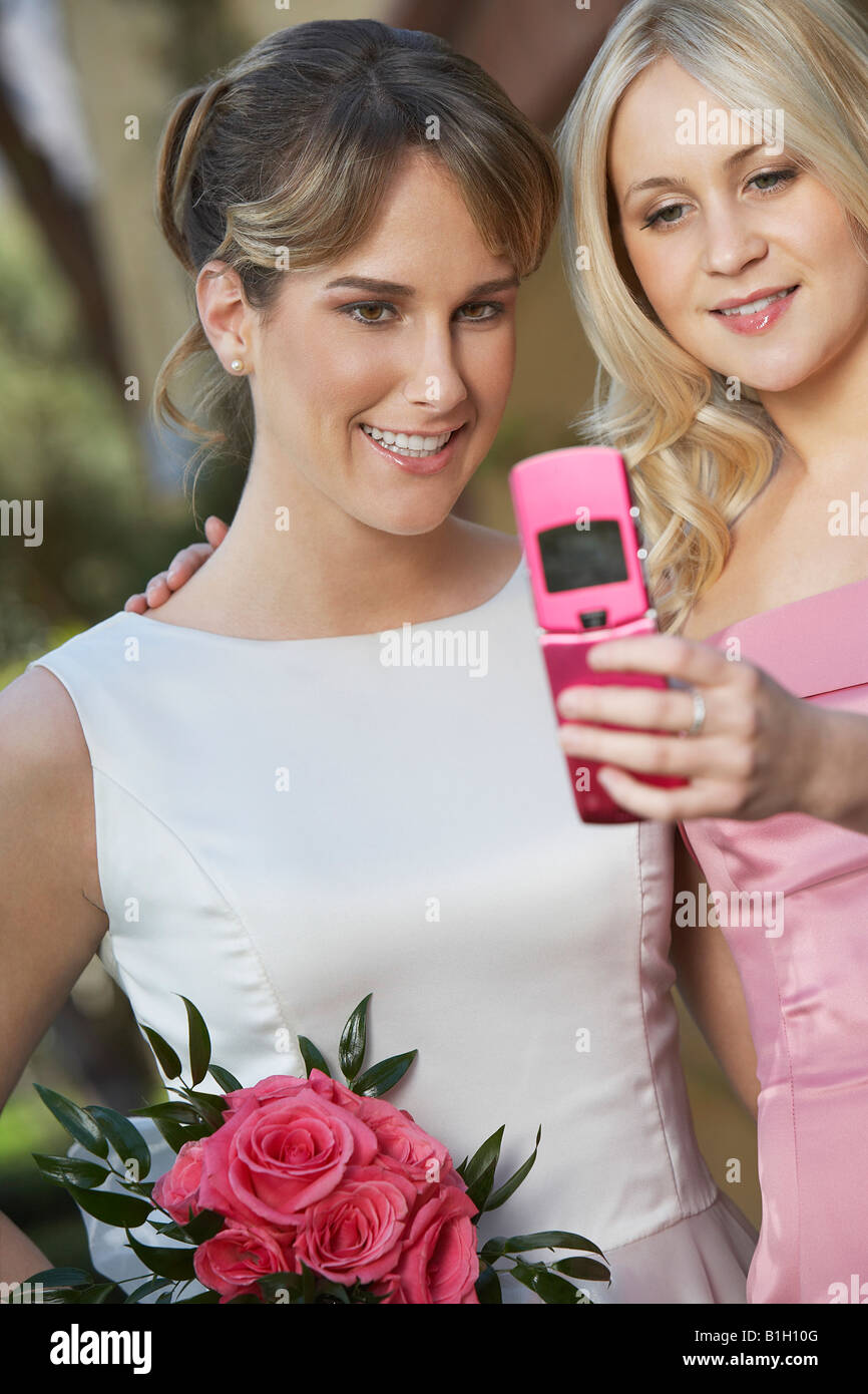 Bridesmaid photographing bride and self with mobile phone Stock Photo ...