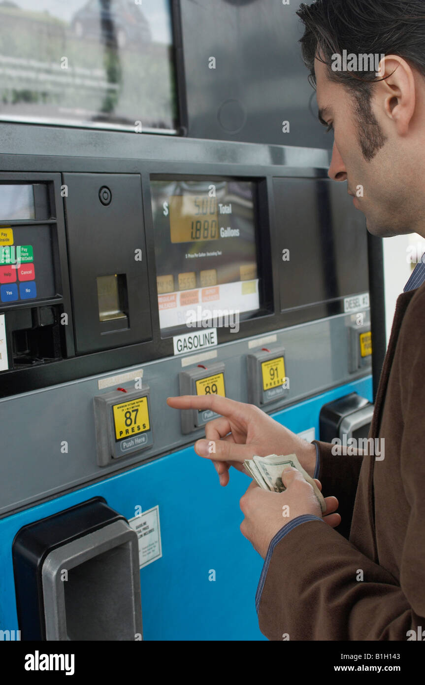 Man pushing buttons on gas pump Stock Photo - Alamy