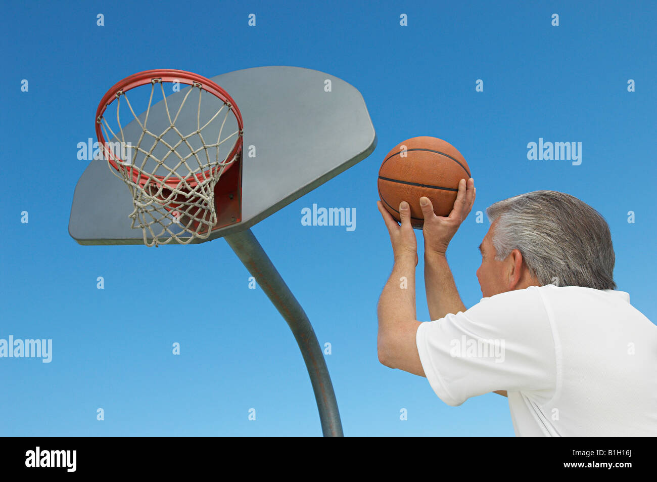 Senior man aiming basketball at hoop, outdoors Stock Photo - Alamy