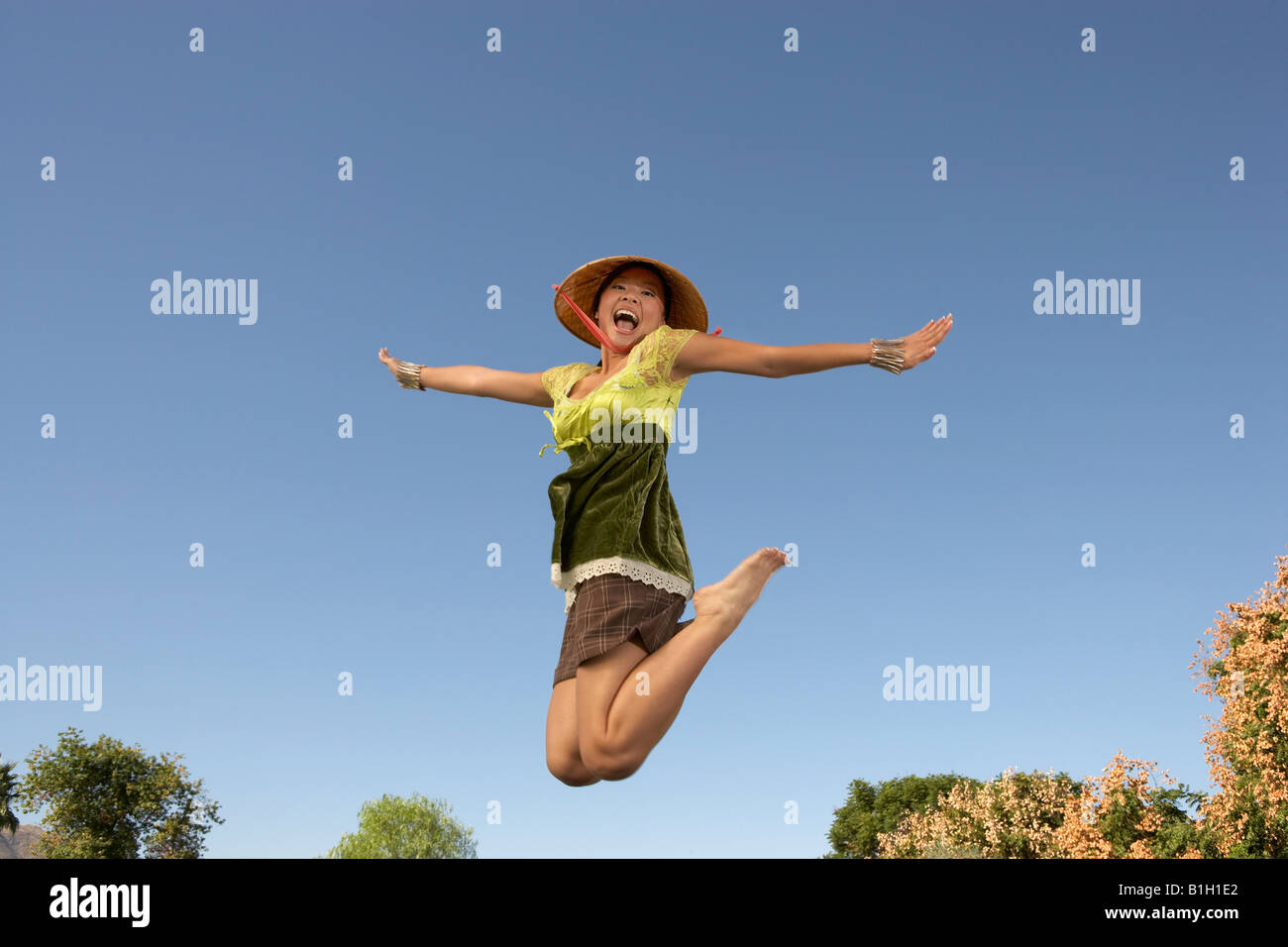 Young woman jumping in park, side view Stock Photo - Alamy