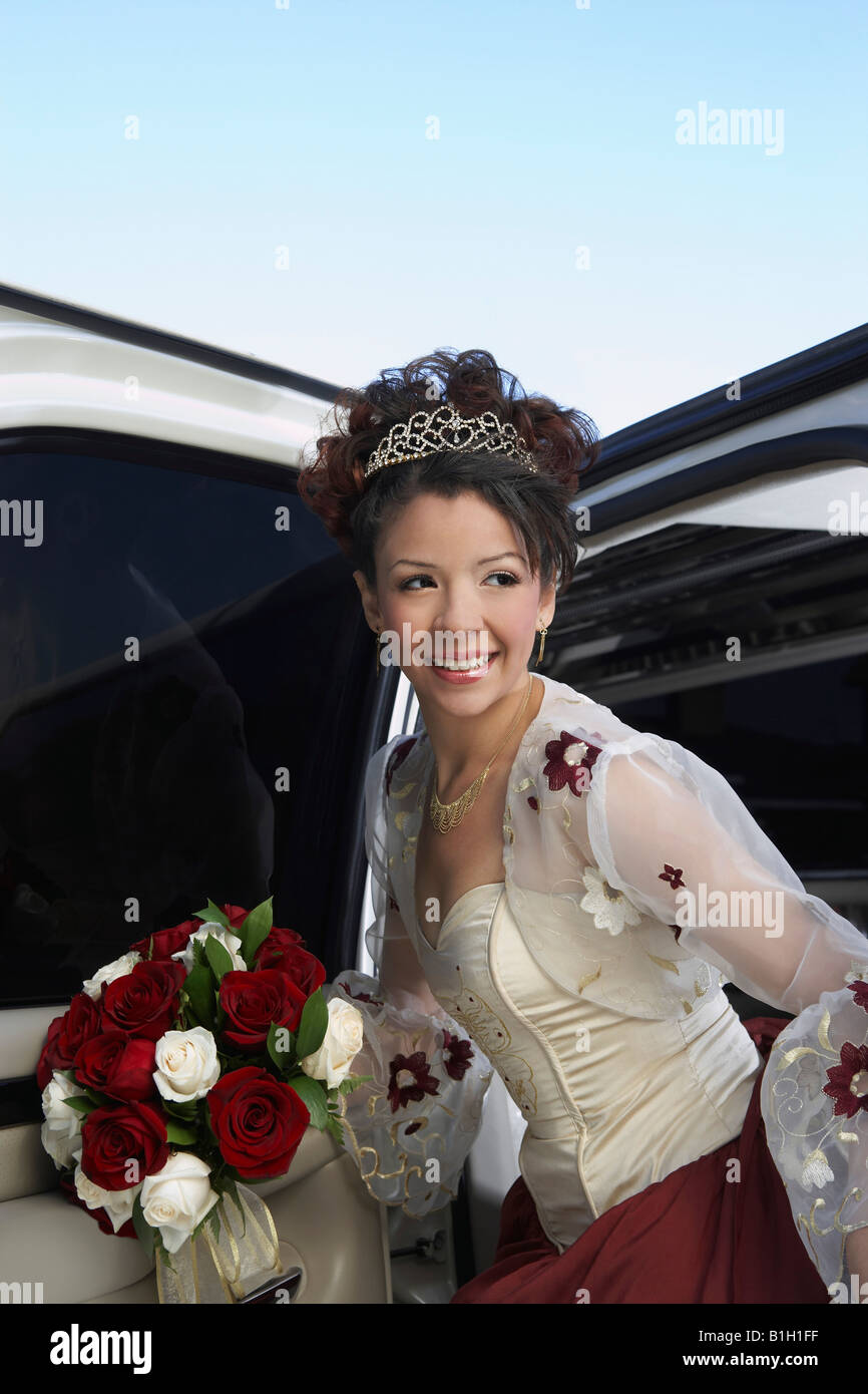 Girl (13-15) with bouquet getting out of limousine at Quinceanera Stock ...