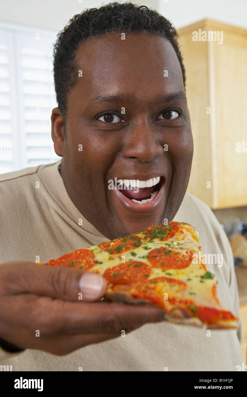 Portrait of man eating pizza Stock Photo - Alamy