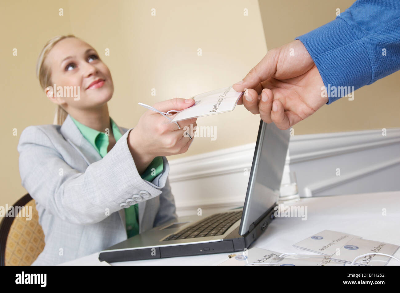 Receptionist distributing name tags Stock Photo - Alamy