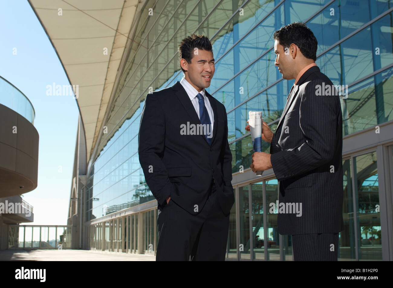Two businessmen talking outside office building Stock Photo - Alamy