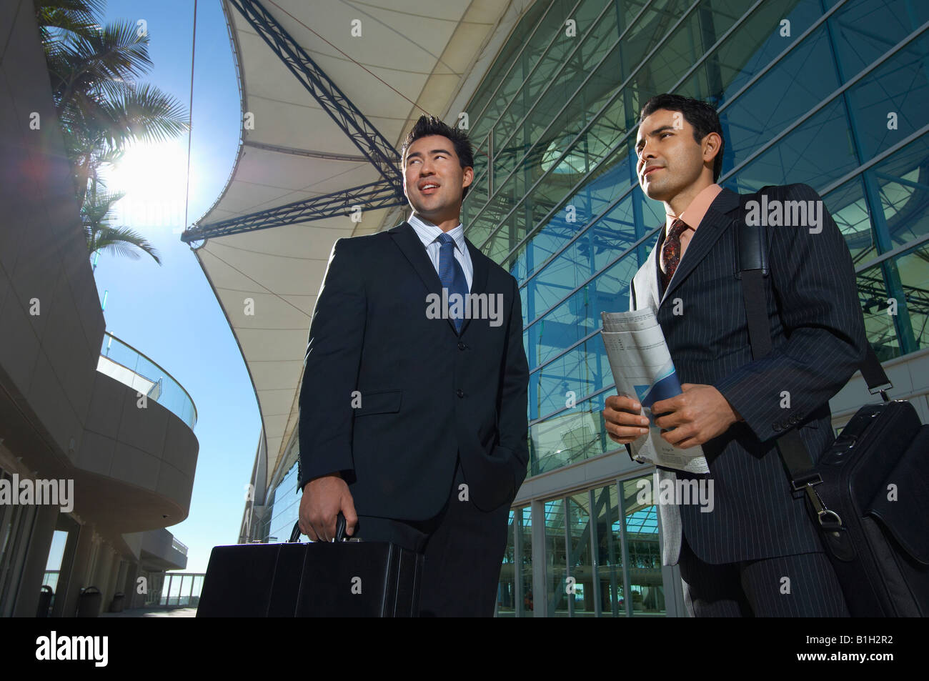 Two businessmen standing outside office building, low angle view Stock ...