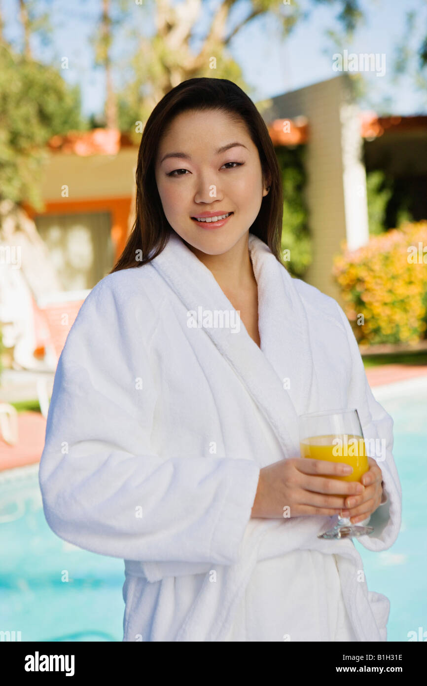 Young woman wearing bathrobe by swimming pool, portrait Stock Photo - Alamy