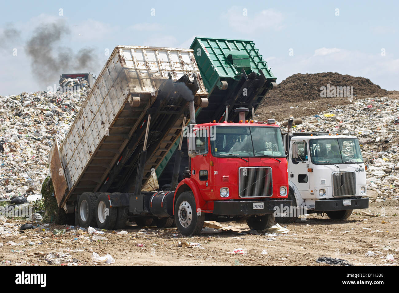 Trucks dumping waste at landfill site Stock Photo - Alamy