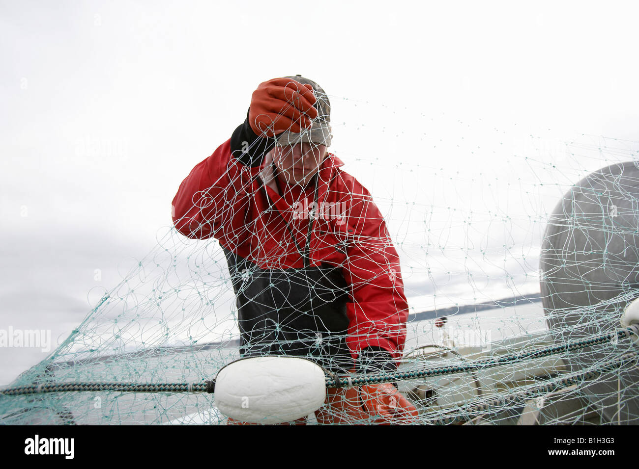 Fisherman holding fishing net on boat Stock Photo - Alamy