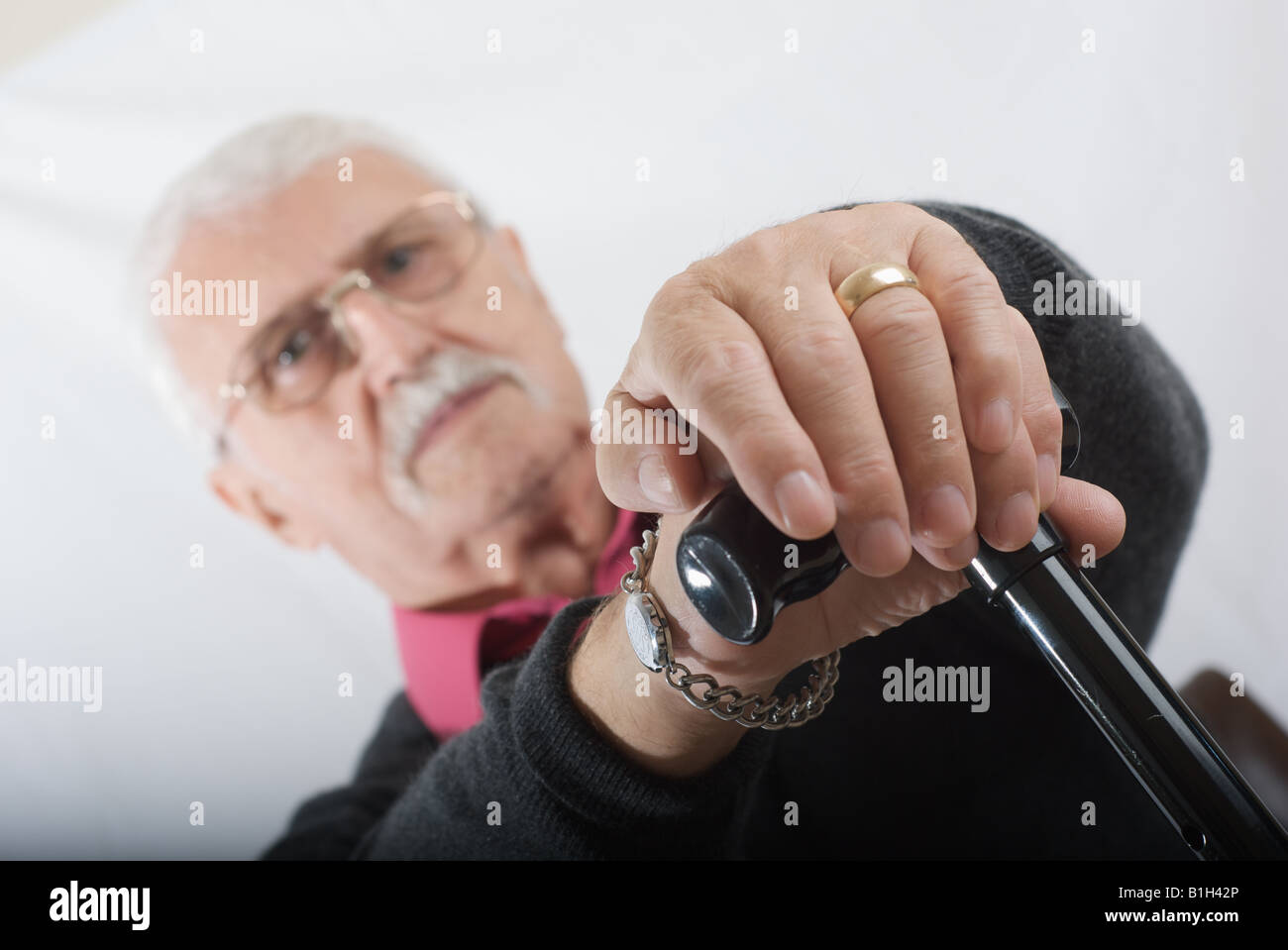 older man leaning on his walking stick Stock Photo - Alamy