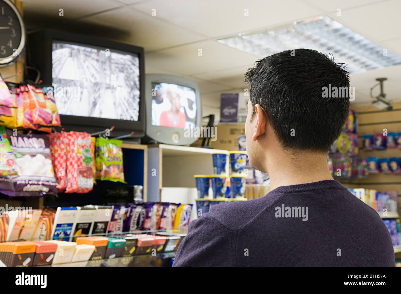 Man watching television in shop Stock Photo - Alamy