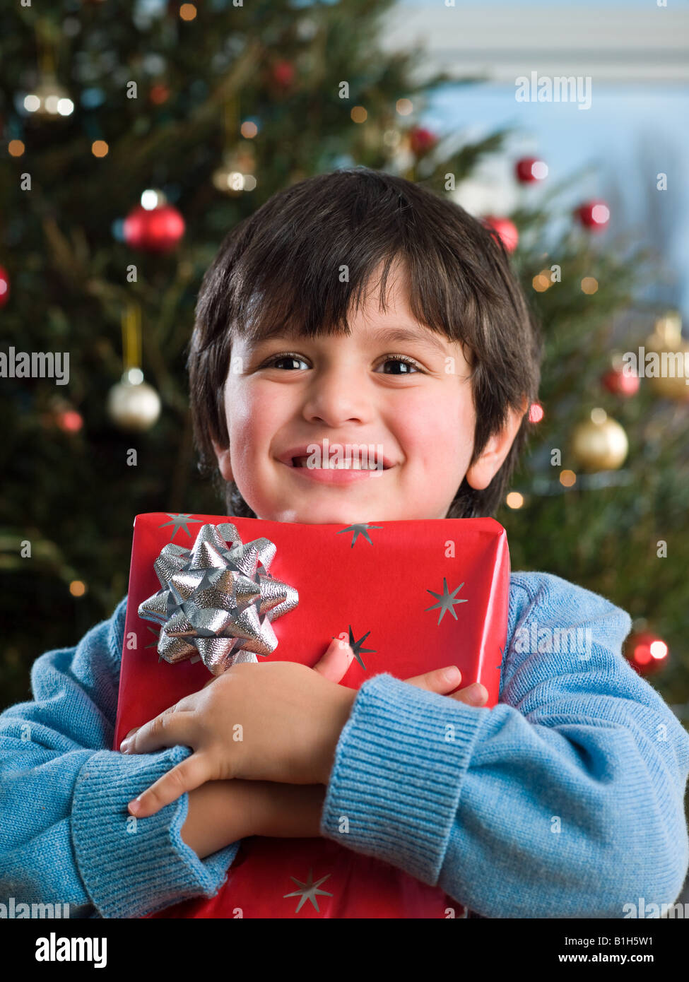 Smiling boy holding a gift Stock Photo - Alamy