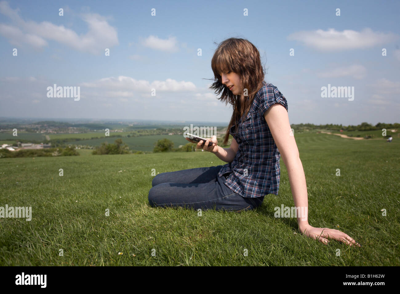 Young woman sending text message outdoors Stock Photo - Alamy