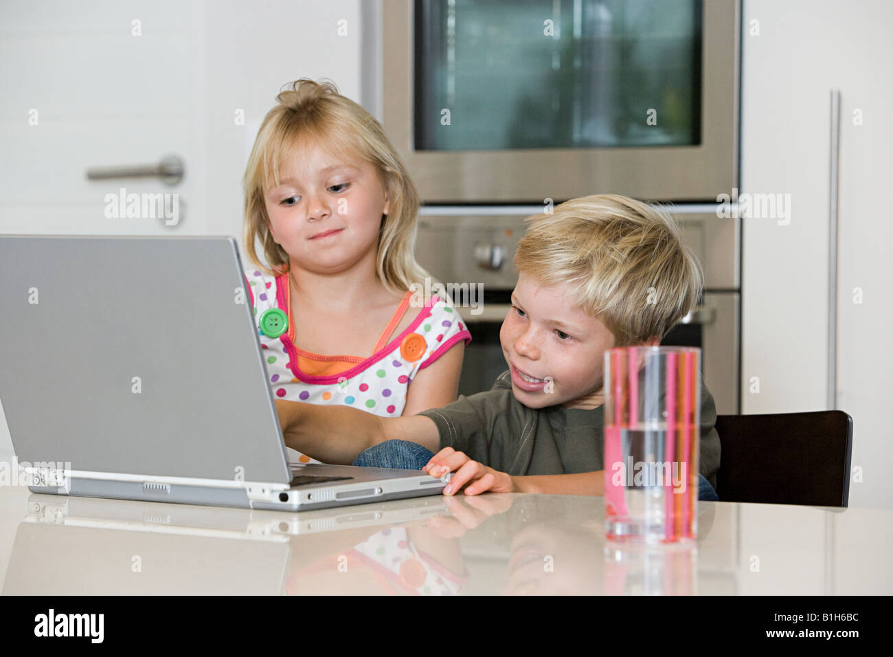 A brother and sister using a laptop Stock Photo - Alamy