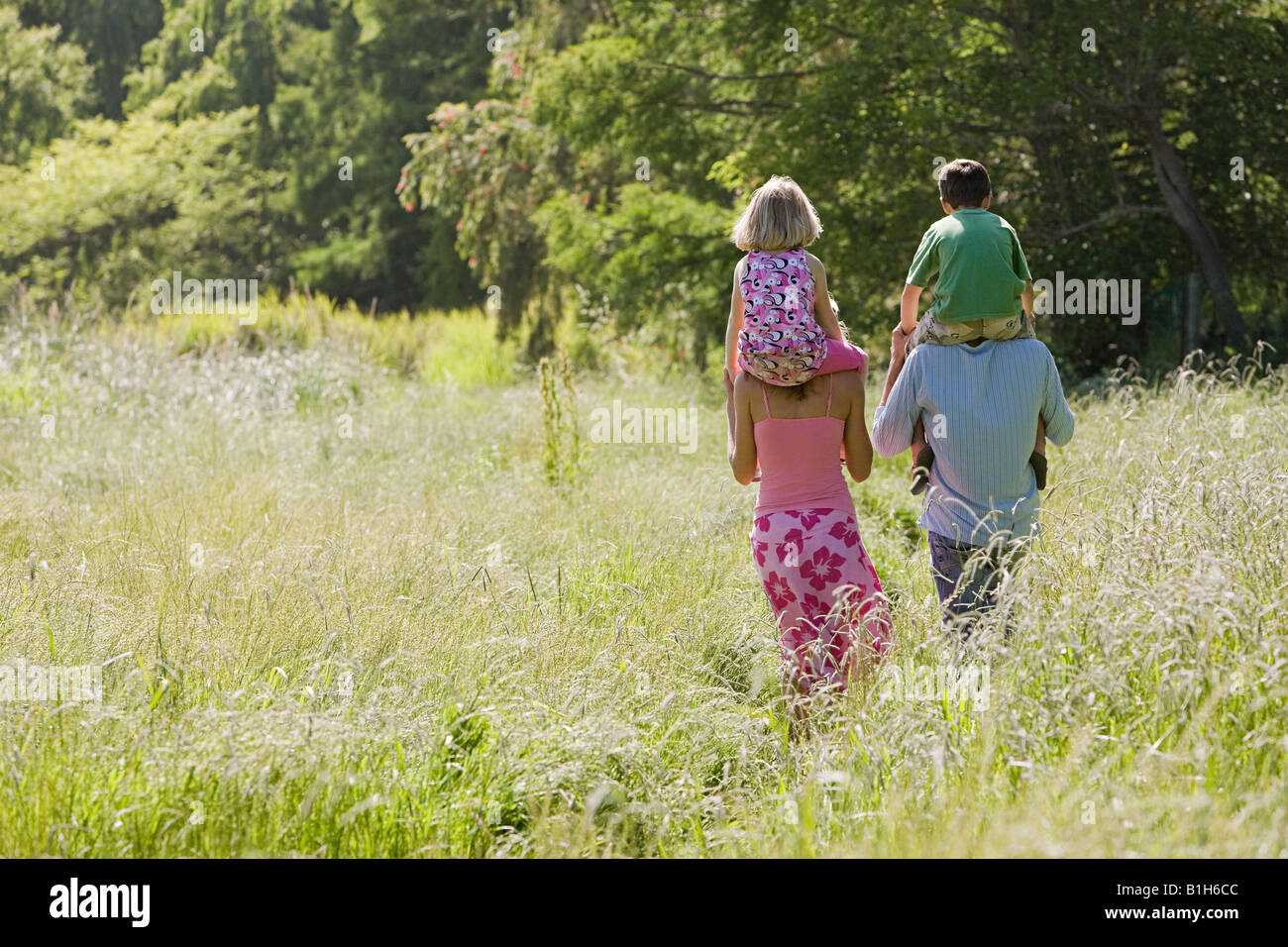 Parents carrying their children on their shoulders Stock Photo - Alamy