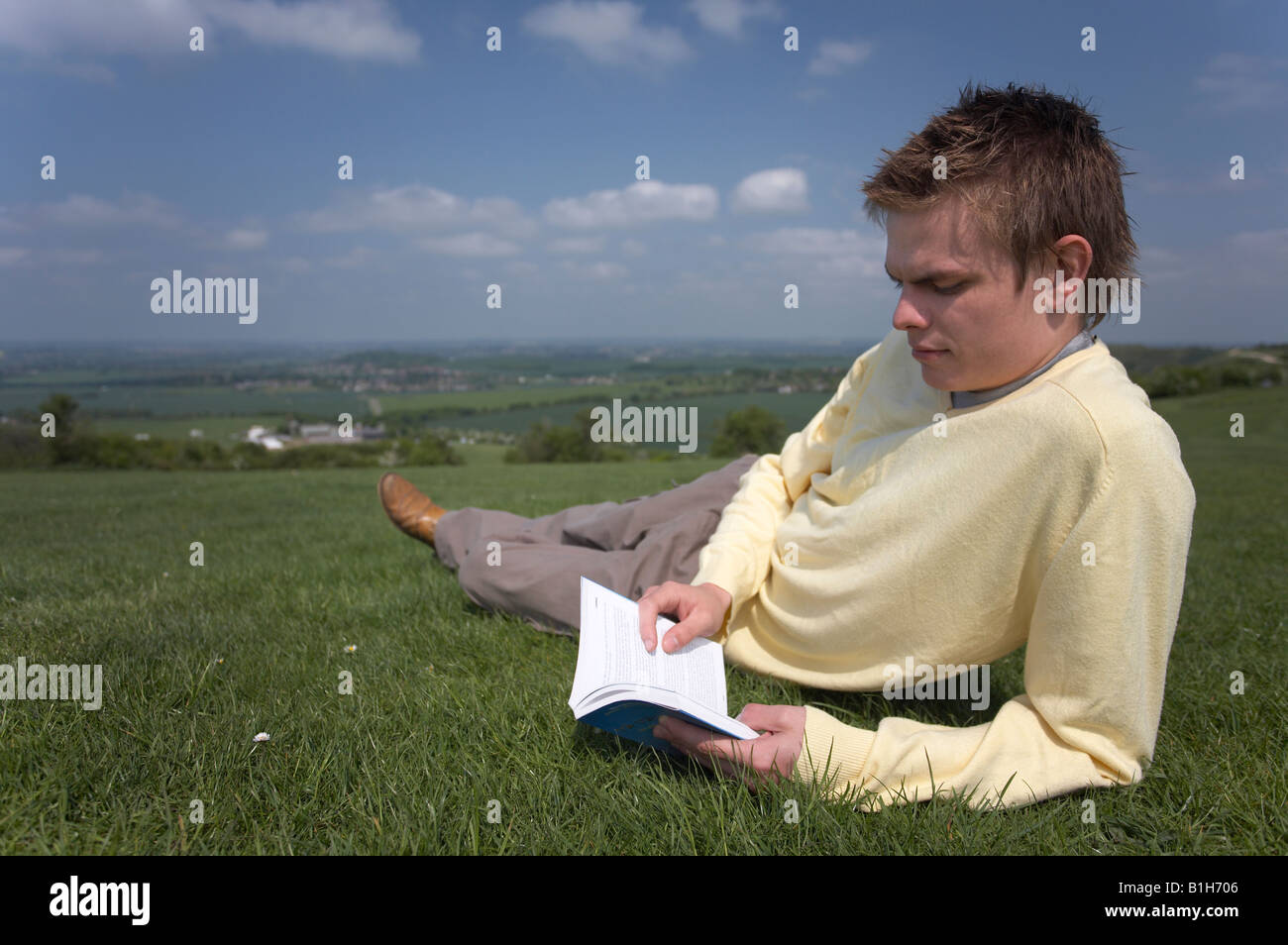 Man reading book outside Stock Photo - Alamy