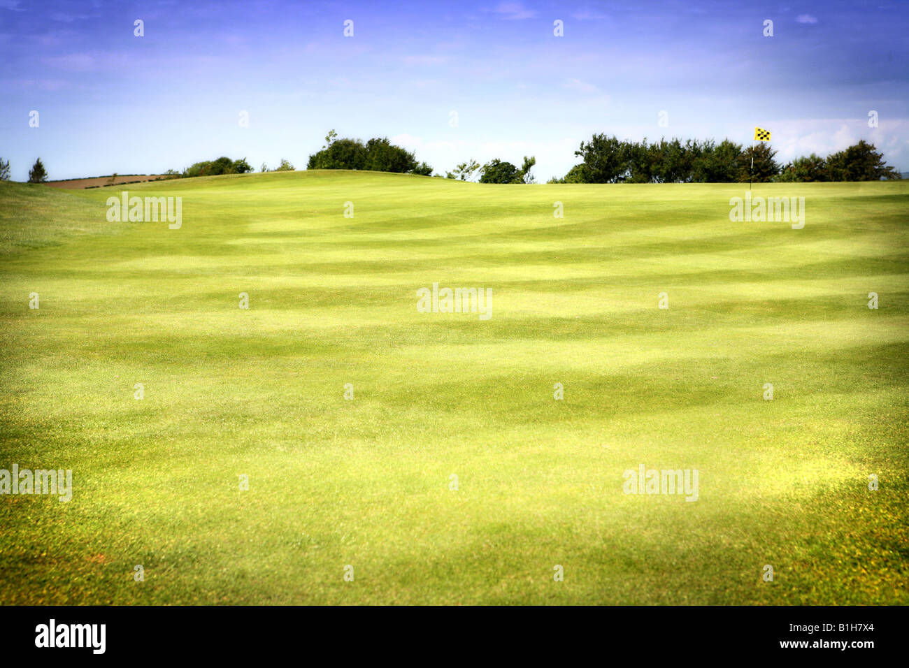 Well manicured golf course fairway approach to putting green hole with ...