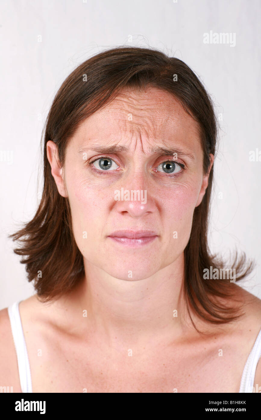 Young brunette woman head shot closeup slightly worried anxious ...