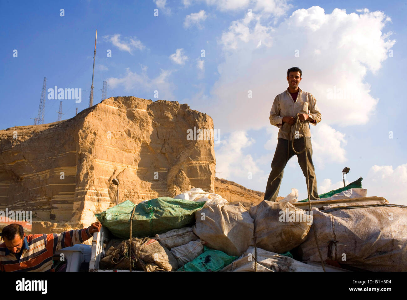 A Zabaleen ties up sacks of garbage on his truck near the Cairo suburb ...