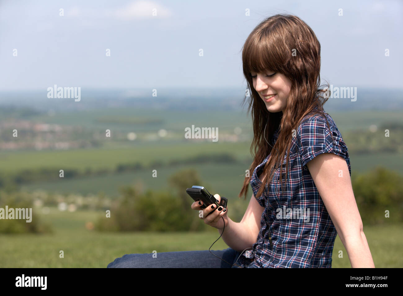 Young woman listening to mp3 player Stock Photo - Alamy