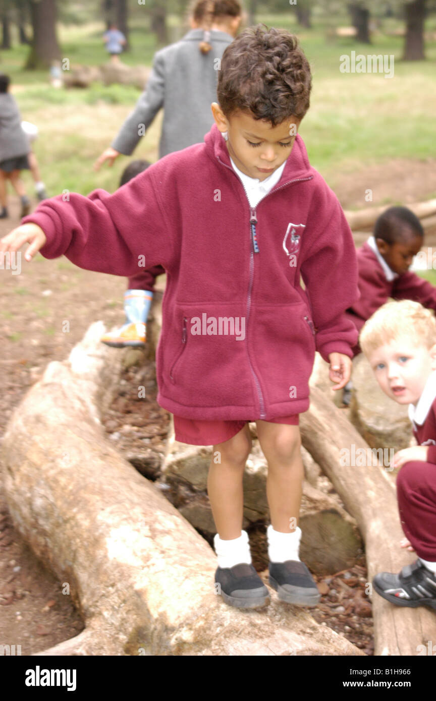 boy balancing on a log in a school playground Stock Photo - Alamy