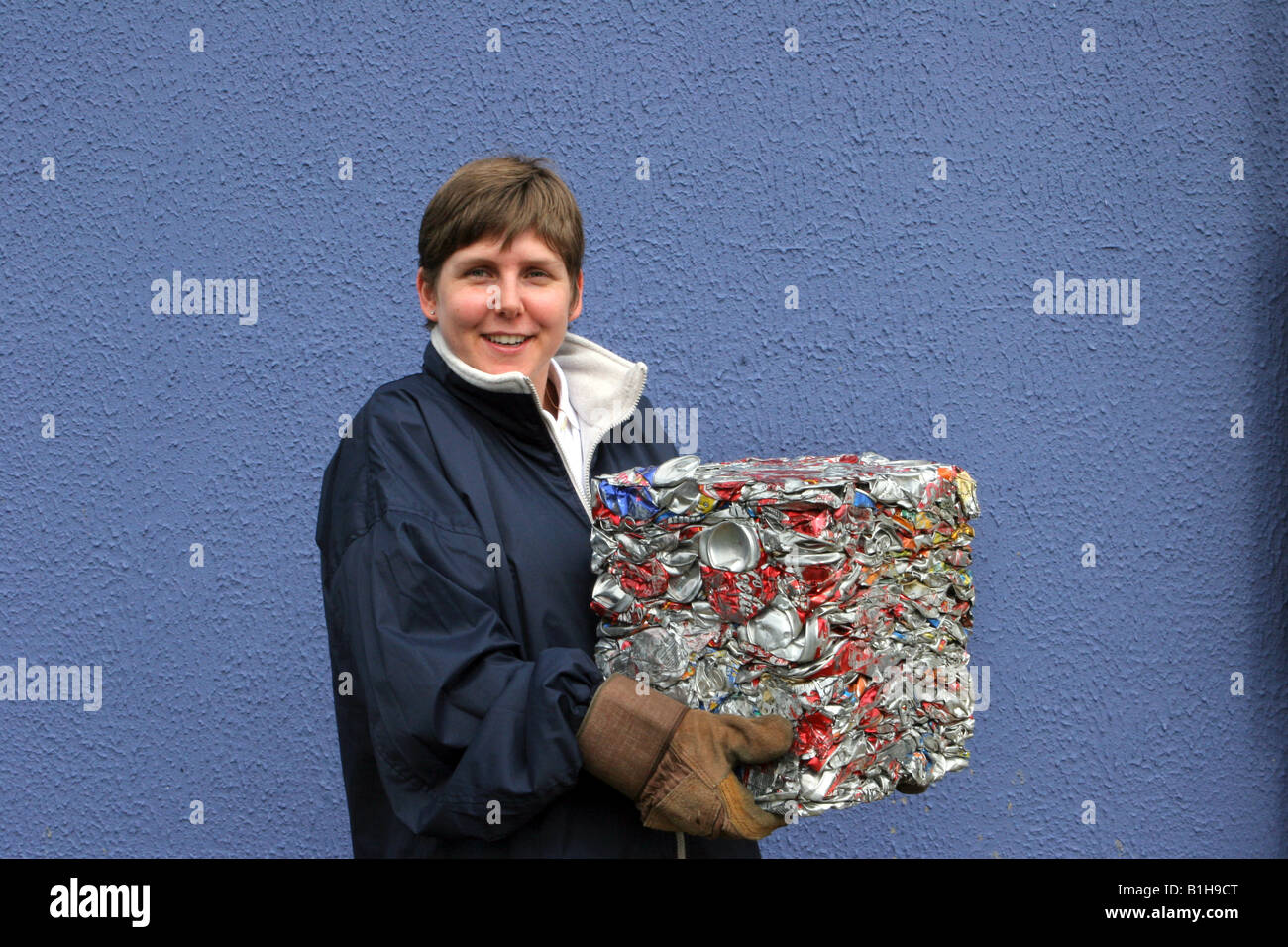 Council employee holding recycled metal trash, refuse, crushed, garbage ...