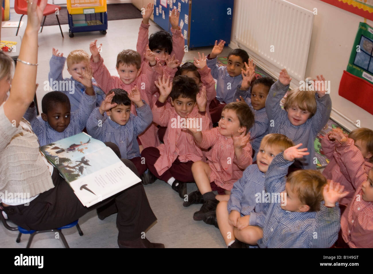 teacher reading to nursery school children Stock Photo - Alamy