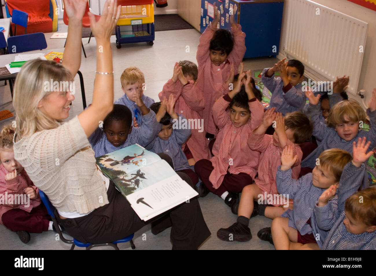 teacher reading to nursery school children Stock Photo - Alamy